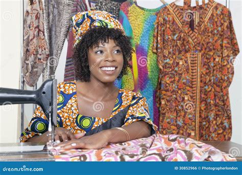 Beautiful African American Female Tailor Looking Away While Stitching