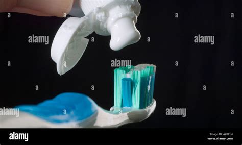 Toothpaste Being Squeezed From A Messy Tube Onto A Toothbrush Picture
