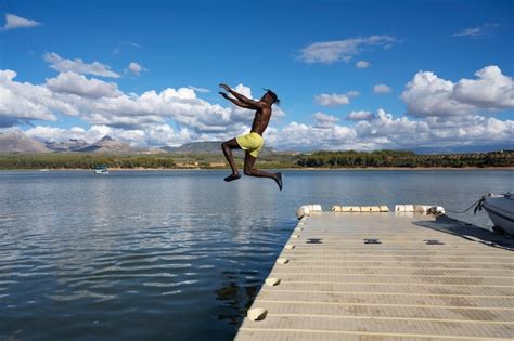 Homem De Tiro Completo Pulando No Lago Foto Grátis