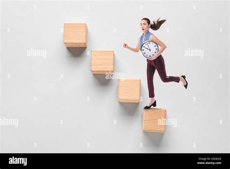 Businesswoman With Clock Climbing Career Ladder On Grey Background