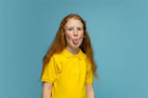 블루 스튜디오 배경에 고립 된 행복한 빨간 머리 소녀 행복하고 쾌활하며 성실한 것처럼 보입니다 복사 공간을 참조하십시오 어린 시절 교육 감정 개념 6 7 살에 대한 스톡