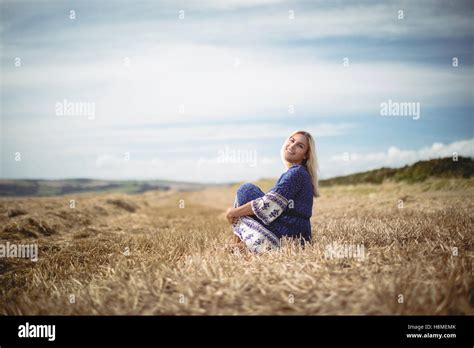 Blonde Woman Sitting In Field Stock Photo Alamy