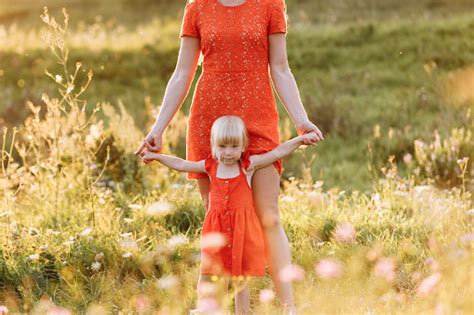 어머니의 초상화는 여름 방학에 딸을 잡고 던지고 자연에 손을 대고 회전합니다 엄마와 소녀는 일몰 시간에 공원에서 재생 친절한 가족의 개념 2 3 살에 대한 스톡 사진 및