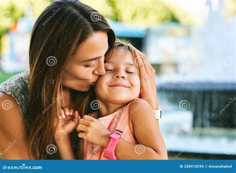 Joven Madre Dando Un Beso A Su Dulce Pequeña Hija Foto De Archivo