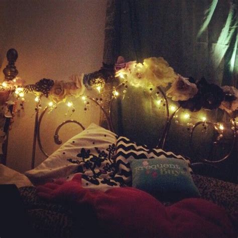 A Bed With Lights On The Headboard And Pillows
