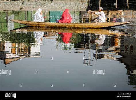 Mirror Image Photo Of Two Muslim Women With Back To The Camera And Boat