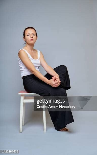 Redhead Woman Sitting On Stool Dressed In Wide Baggy Pants High Res