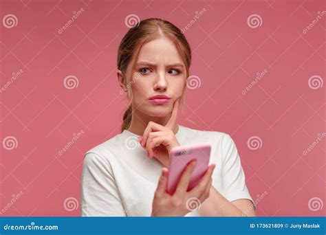 Confused Young Redhead Woman Holding Pink Smartphoneembarassed Girl