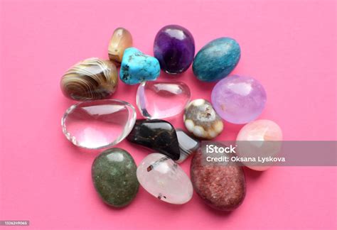 다양한 색상의 텀블 과 거친 보석과 결정 자수정 로즈 쿼츠 Agate Apatite Aventurine 올리바인 분홍색 배경에