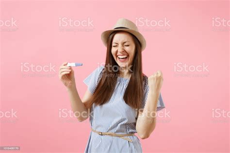 파란 드레스에 흥분된 행복 한 여자 모자 잡고 손 임신 테스트 분홍색 바탕에 고립 된 보고 의료 의료 부인과 임신 임신 출산