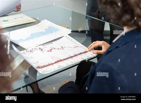 Selective Focus On A Finance Graph And Unrecognizable People Out Of Focus Anonymous Businessman
