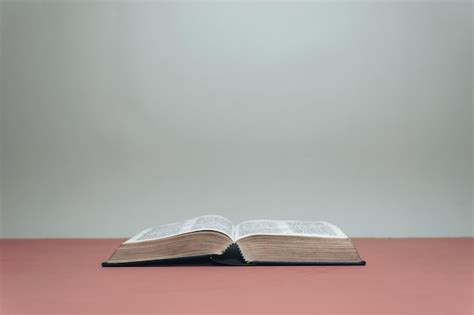 Biblia Abierta En Una Mesa Roja Fondo De La Pared Gris Foto Premium