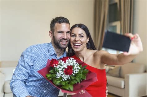 Image Of Happy Young Couple Taking Selfie Photo With Flowers While
