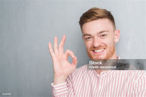손가락 우수한 기호 확인 표시를 하 고 회색 그런 지 벽에 빨강 머리 젊은 남자 개념에 대한 스톡 사진 및 기타 이미지 개념 개념과 주제 그런지 이미지 기법 Istock