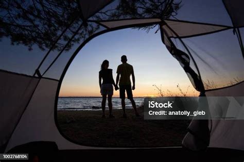 젊은 커플 남자와 여 자가 나머지 관광 텐트에 있고 바다 해안 숲 근처에 캠프 파이어를 굽기 일몰에 대한 스톡 사진 및 기타 이미지 Istock