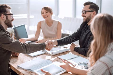 Smiling Business Partners Shaking Hands At A Business Meeting Stock