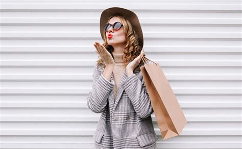 코트 흰색 배경에 둥근 모자를 입고 립스틱으로 입술을 불고 쇼핑 백과 아름다운 젊은 여성의 가을 초상화 25 29세에 대한 스톡 사진 및 기타 이미지 Istock