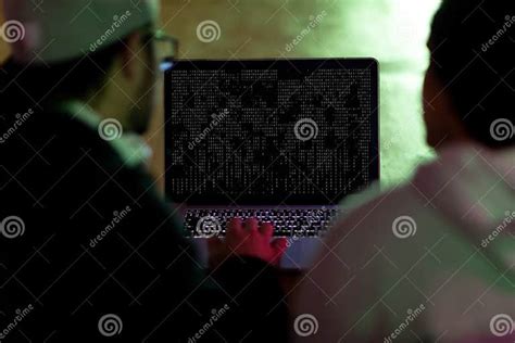 Back View Of Two Diverse Male Colleagues At Desk Using Computer With Coding On Screen Stock