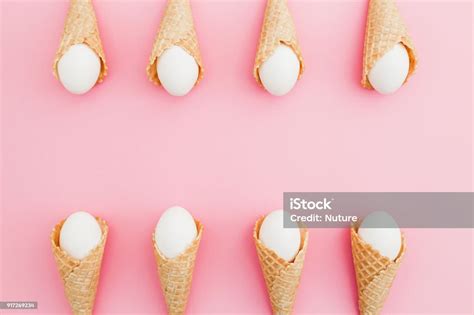 파스텔 핑크 바탕에 와플 콘에 부활절 흰 계란 프레임에 의하여 이루어져 있다 상위 뷰 플랫이 하다 부활절 휴가 개념 0명에 대한