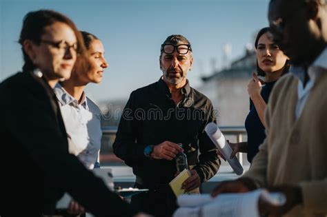 Multicultural Business Workers Discussing A Project On A Rooftop Stock