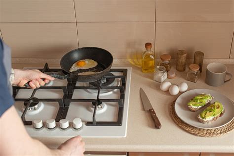 부엌에서 아침 식사로 아보카도와 달걀로 토스트를 준비하는 청년 30 39세에 대한 스톡 사진 및 기타 이미지 30 39세