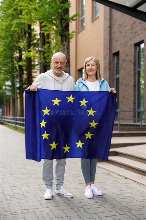 Retrato De Amigos Maduros Con Una Bandera De La Unión Europea Mirando Y