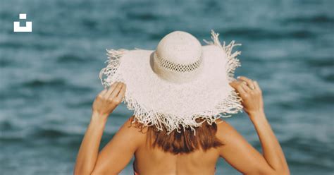 흰색 태양 모자를 쓰고 흰색과 빨간색 꽃 비키니를 입은 여자 동안 바다 해안에 서 사진 Unsplash의 무료 바다 이미지