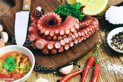 나무 도마 배경에 문어 음식 요리 오징어 샐러드 칠리 소스 해산물 오징어 저녁 식사 레스토랑 삶은 문어 촉수 갑오징어류에 대한