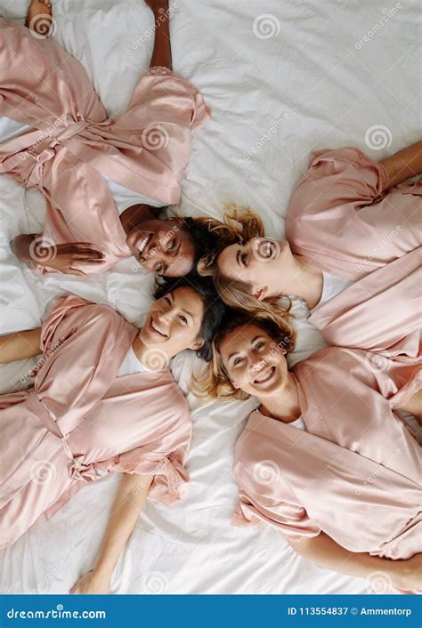 Bruid Met Bruidsmeisjes Die Bij Bed En Het Glimlachen Liggen Stock