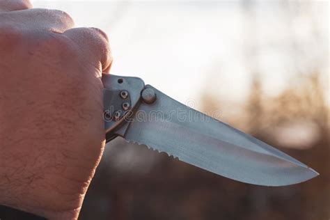 Un Cuchillo En La Mano De Un Hombre Con Una Cuchilla De Acero Afilada