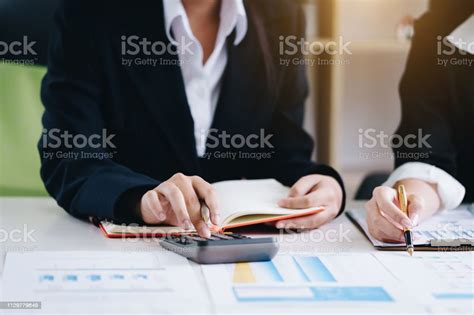 비즈니스 여자 보고서와 파트너십을 가리키는 펜을 들고 사무실에 나무 테이블에 계산기와 마케팅 계획 분석 개념에 대한 스톡 사진