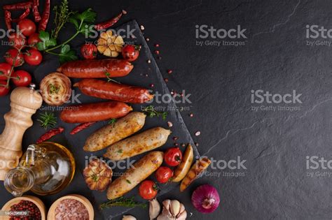 요리용 소시지와 재료 허브와 향신료 야채 로즈마리 그릴 접시에 백리향 그릴 음식 바베큐 돌 테이블에 구운 소시지 맨 위