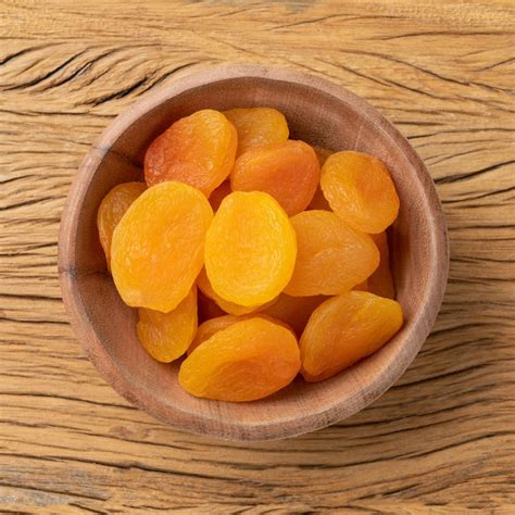 Premium Photo Dried Apricots In A Bowl Over Wooden Table