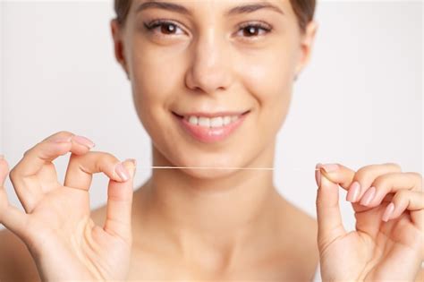 Close De Uma Mulher Passando Fio Dental Nos Dentes Com Fio Dental