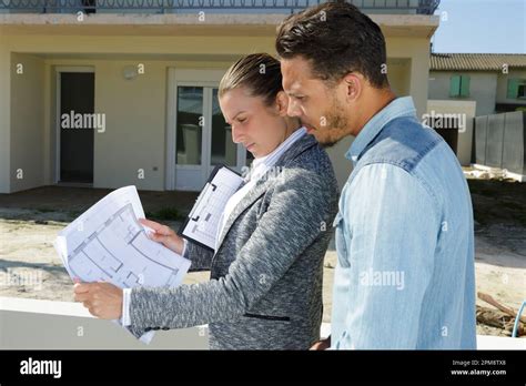 Man And Woman Consulting Consulting Layout Plans For Property Stock