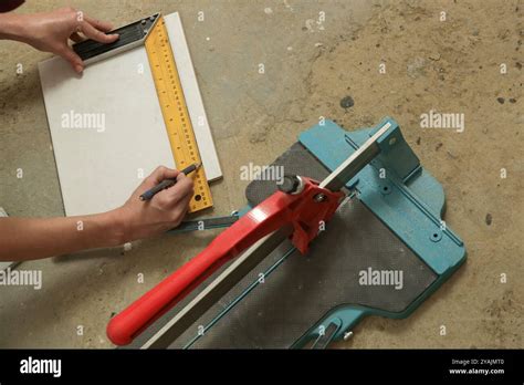 Woman Doing Measurements And Cutting Tiles With A Standard Manual Tile