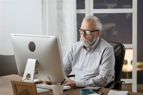 Premium Photo Senior Retired Man Sitting Ad Desk And Working With A