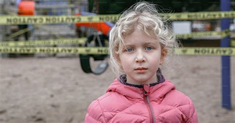 야외에서 닫힌 놀이터에서 슬픈 화가 난 백인 소녀의 초상화 캐나다 토론토에서 노란색 주의 테이프로 잠긴 어린이 놀이 공간 코로나 바이러스 사회적 거리 격리 사진