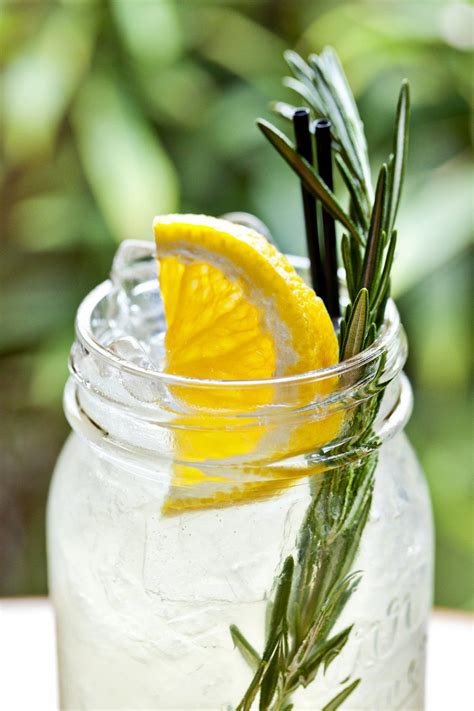 Mason Jar Cocktail Garnished With Rosemary Sprig And Lemon Slice From