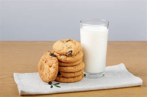 Premium Photo Glass Of Milk And Cookies With Raisins On The Table