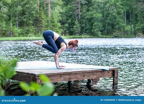 Girl Practicing Yoga Doing Bakasana Exercise Crane Pose On The Lake
