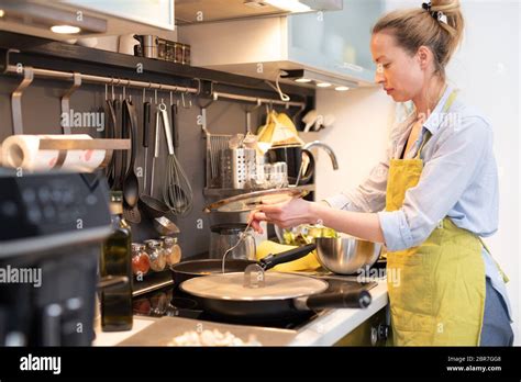Stay At Home Housewife Woman Cooking In Kitchen Stir Frying Dish In A