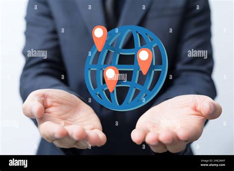 Businessman Holding A Floating Render Of A Globe With Marked Locations