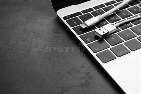 Usb Cable With Type C Connector And Laptop On Dark Table Closeup