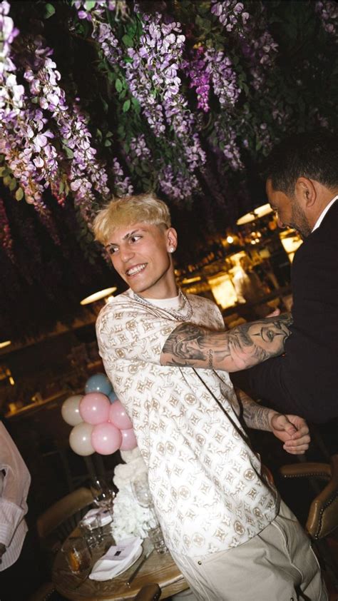 A Man Standing Next To A Woman With Tattoos On Her Arm