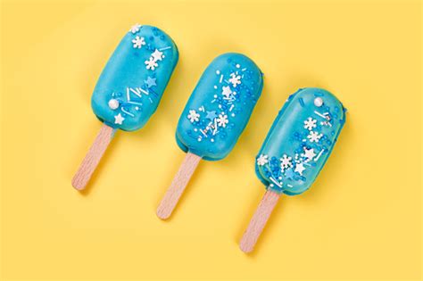 노란색 배경에 블루 민트 아이스크림 아이스캔디 스틱에 맛있고 상쾌한 아이스크림 최소한의 여름 컨셉 플랫 레이 감정에 대한 스톡