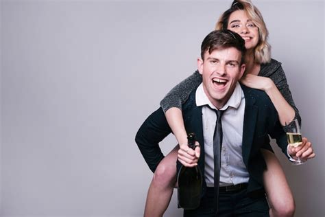 Free Photo Young Woman Sitting On Man Back With Champagne