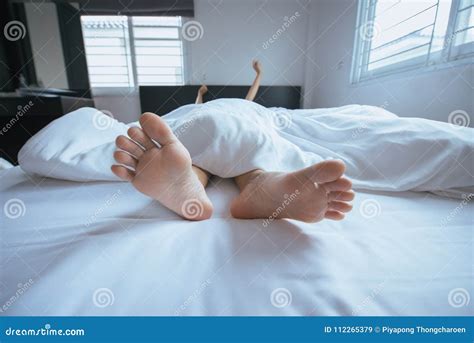 Close Up Of Barefootfeet And Stretch Lazily On The Bed Stock Image