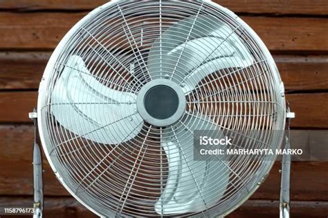 나무 벽의 배경에 대한 테이블에 큰 탁상 환기 열 더운 날씨 에어컨의 개념 Rotary International에 대한 스톡