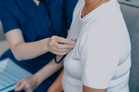 Caucasian Female Doctor Uses Stethoscope To Check Heart Rate On Elderly